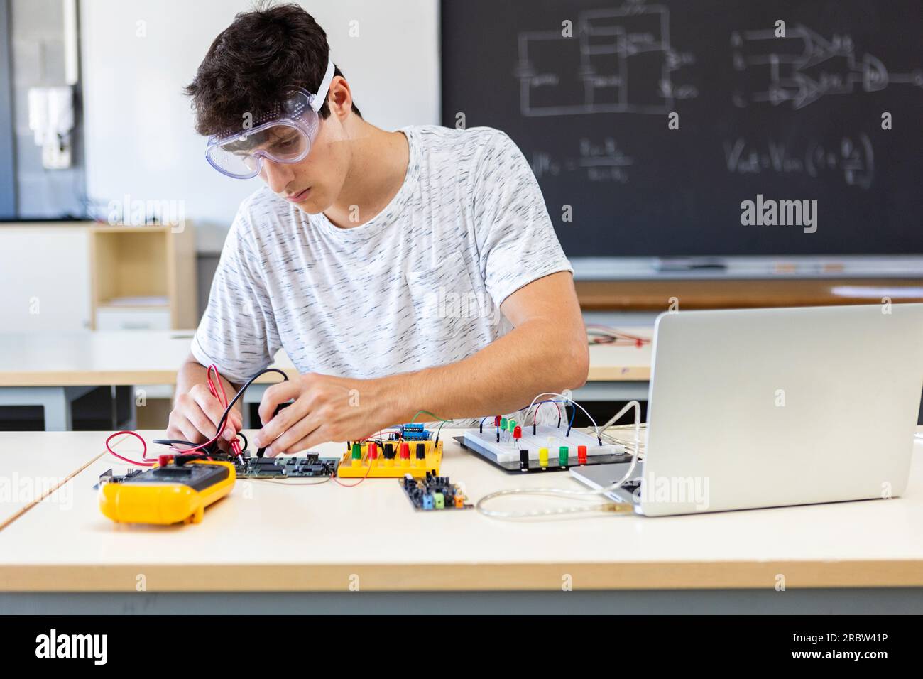 Young tech male student learning electronic circuit system at school ...