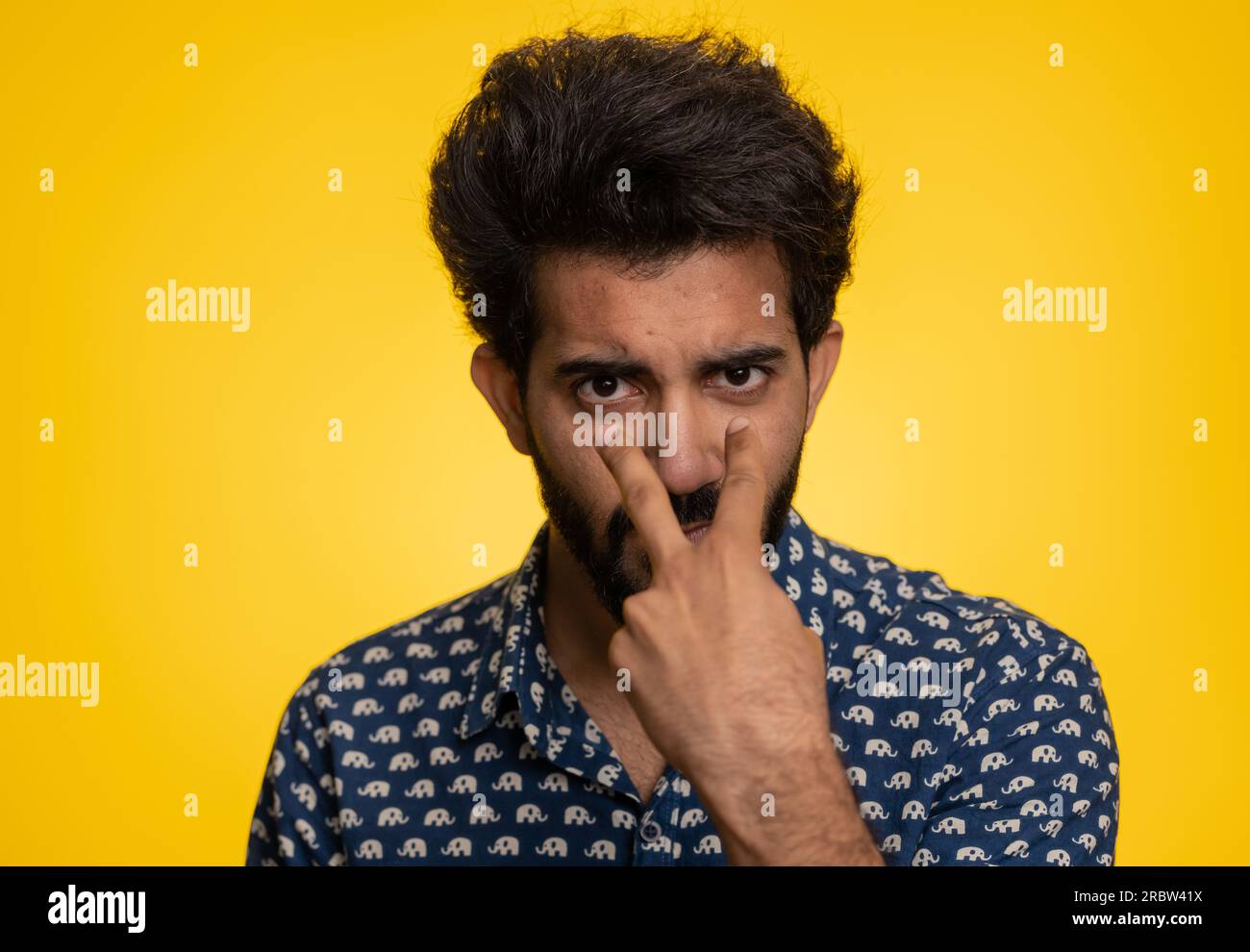 I am watching you. Young confident indian man pointing at his eyes and ...