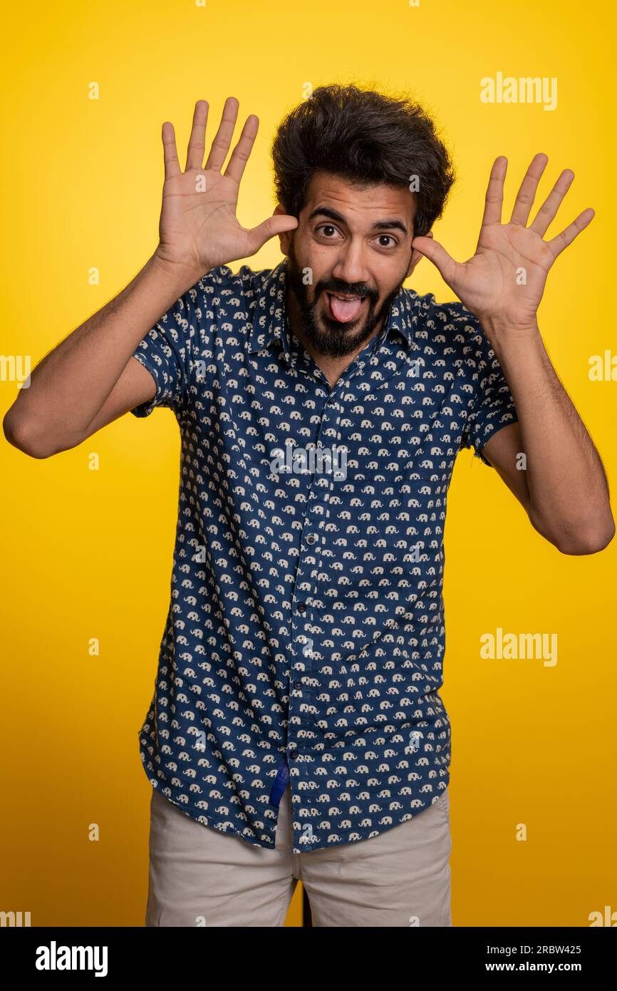 Comical funny young indian man making playful silly facial expressions ...