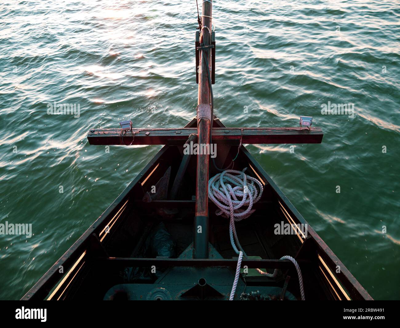 Sailboat bow with mooring rope sailing on the sea waves with turquoise ...