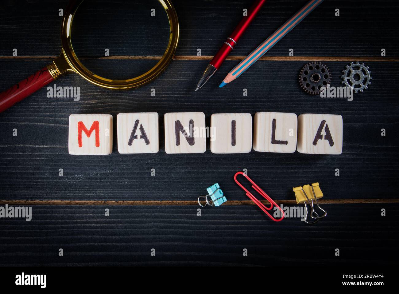 MANILA. City name from blocks on a dark wood texture background Stock ...