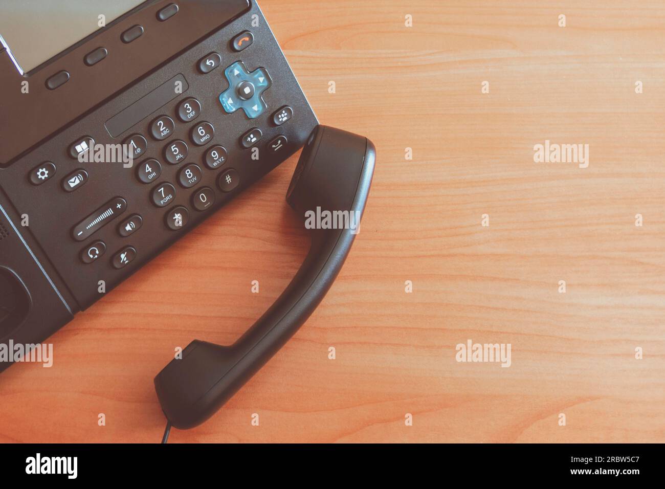 The black desktop push-button telephone. IP phone on desk in office ...