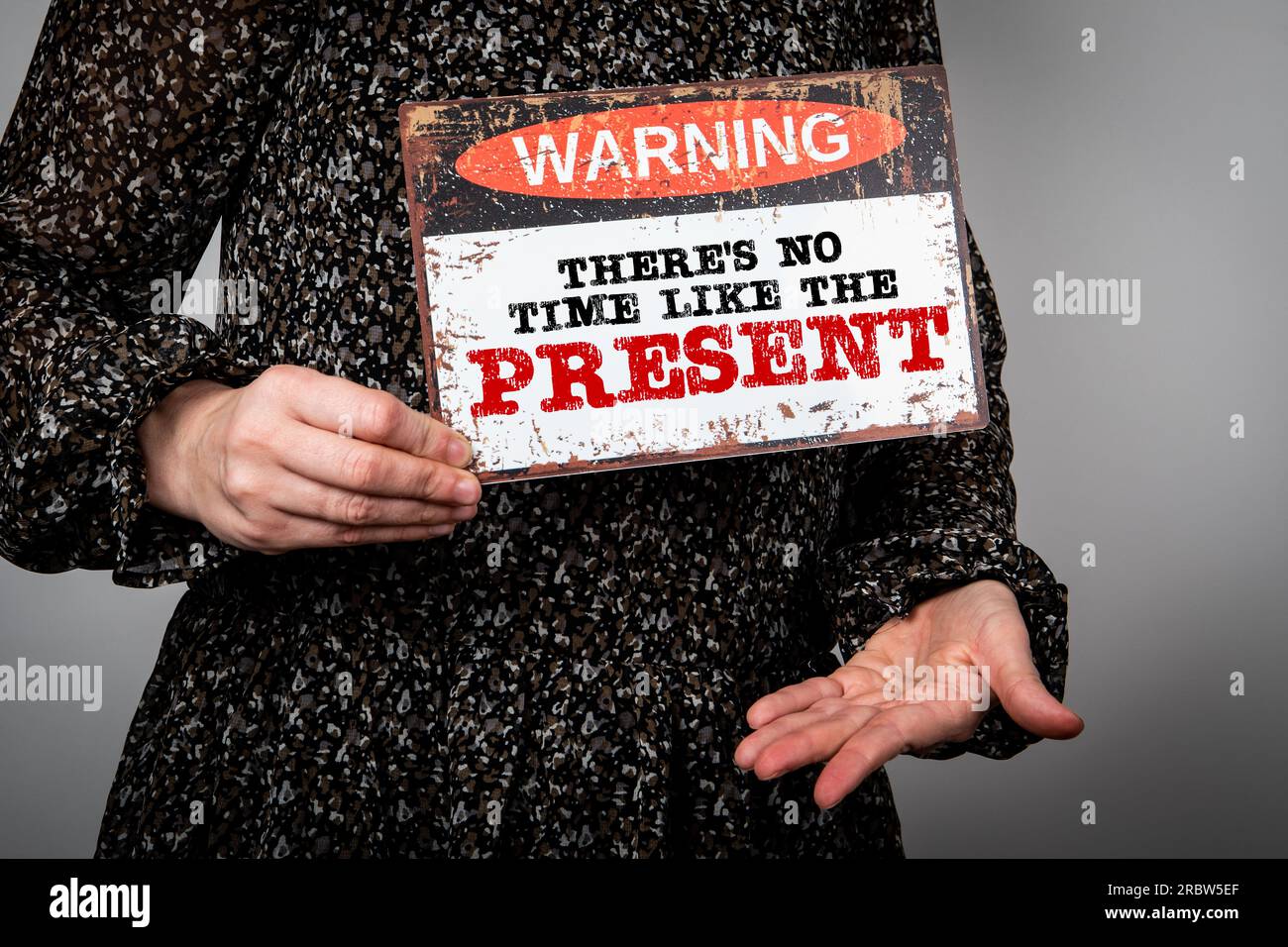 There's No Time Like the Present. Warning sign in woman's hands Stock ...