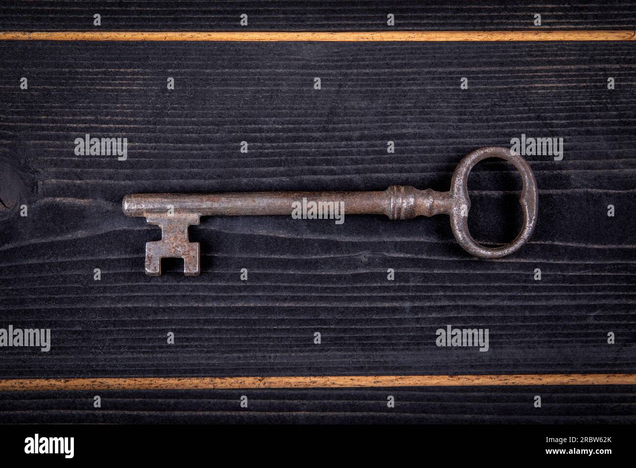 Old rusty key on dark wood texture background Stock Photo - Alamy