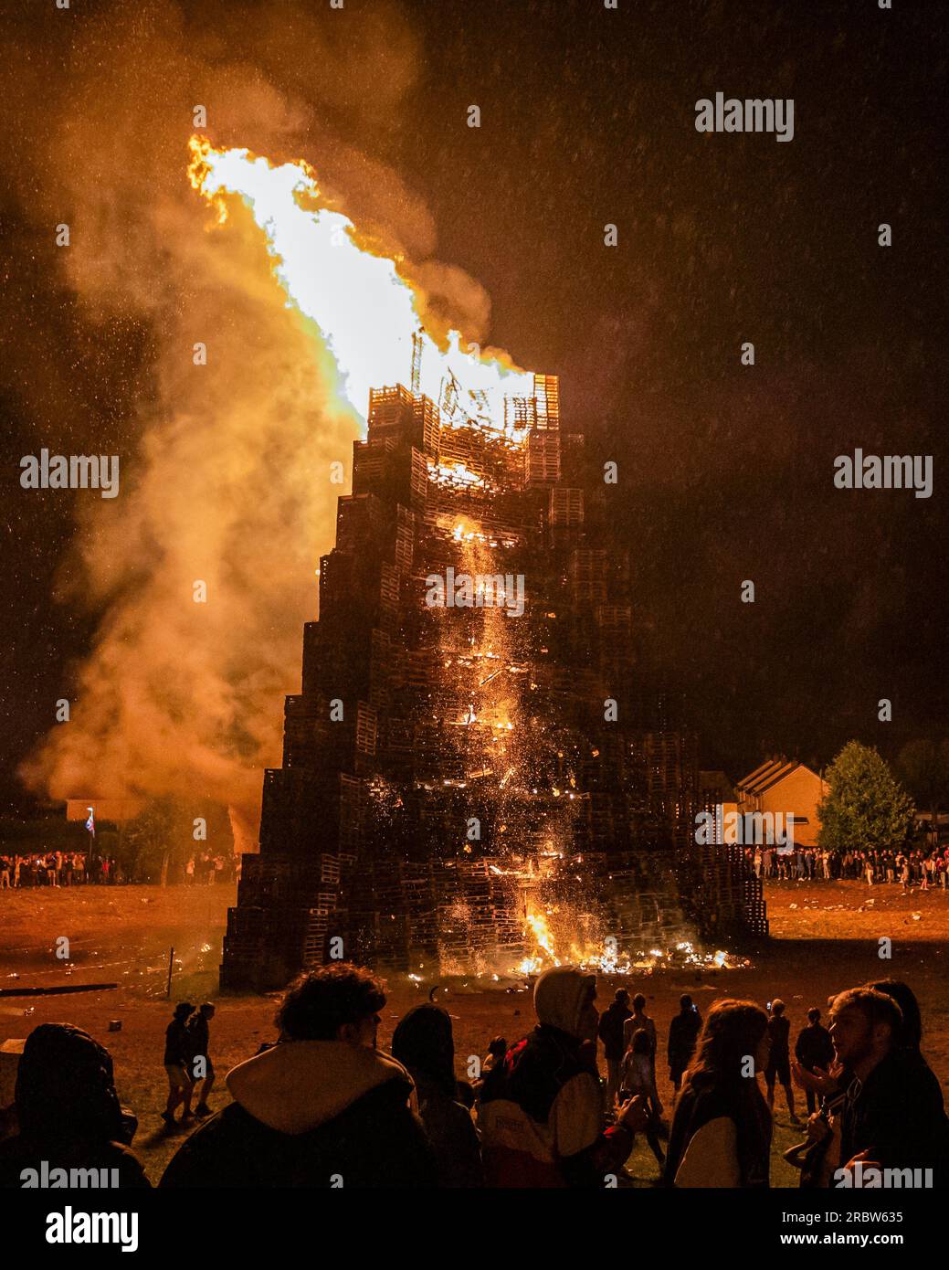 People watch the burning of the loyalist Corcrain bonfire in Portadown ...