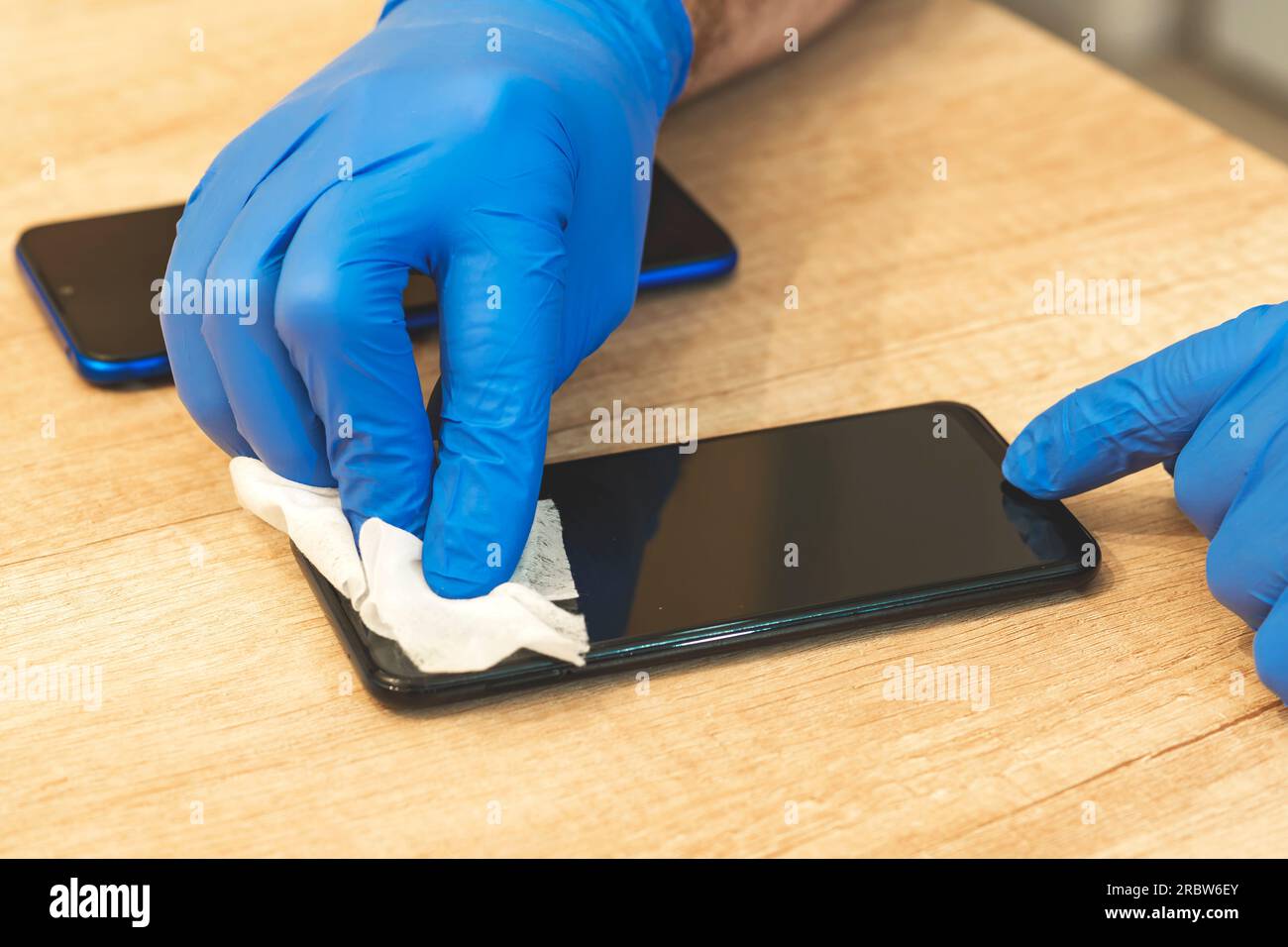 Hands in sterile gloves. Wet disinfectant wipe, napkin. Mobile phone ...