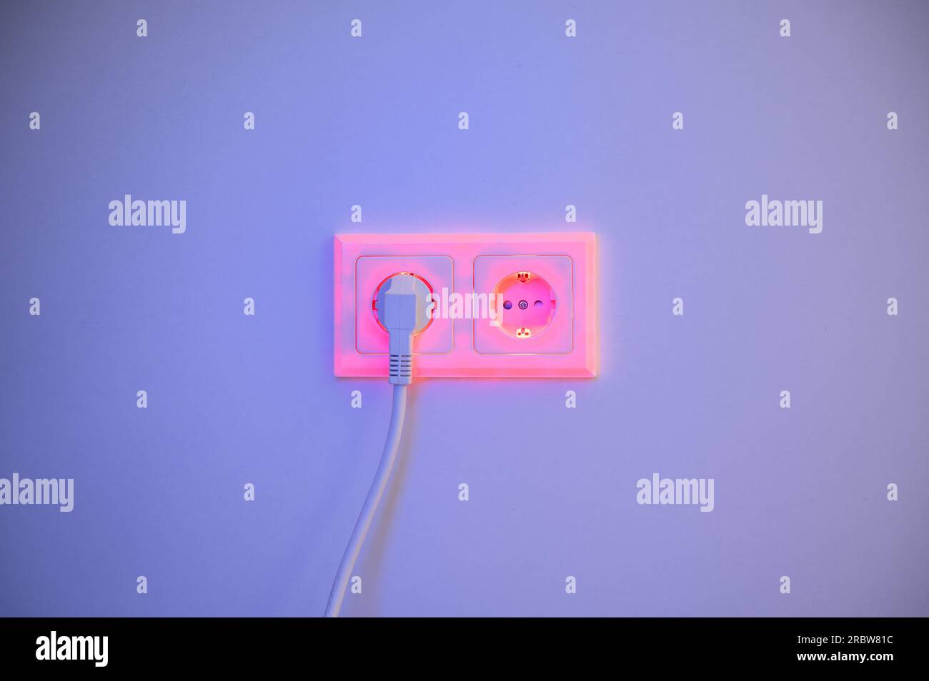 Red and Blue illuminated socket with plug inserted to symbolise power ...