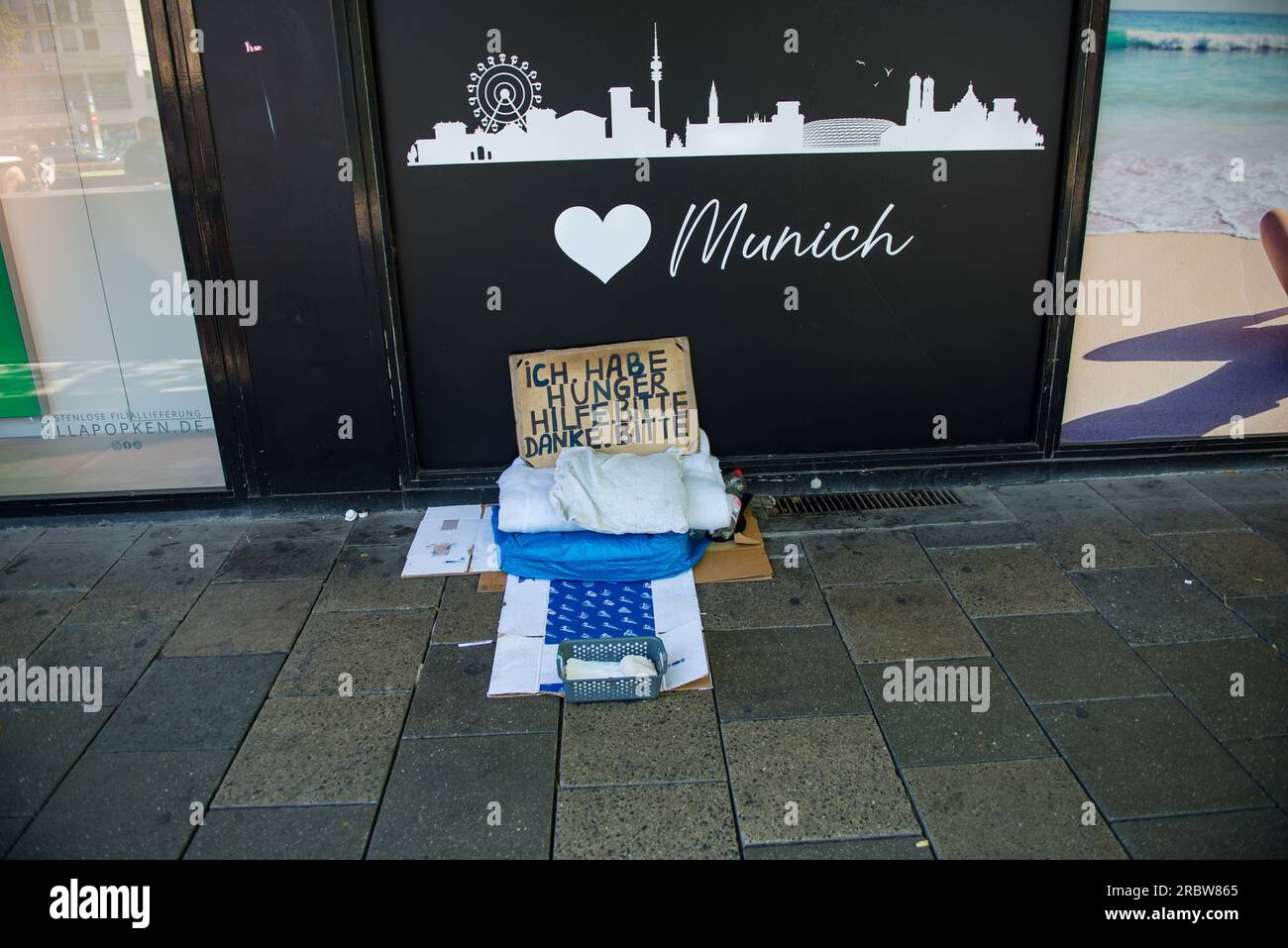 Munich,Germany- July 7,2023: Beggar's cardboard sign in german under a ...