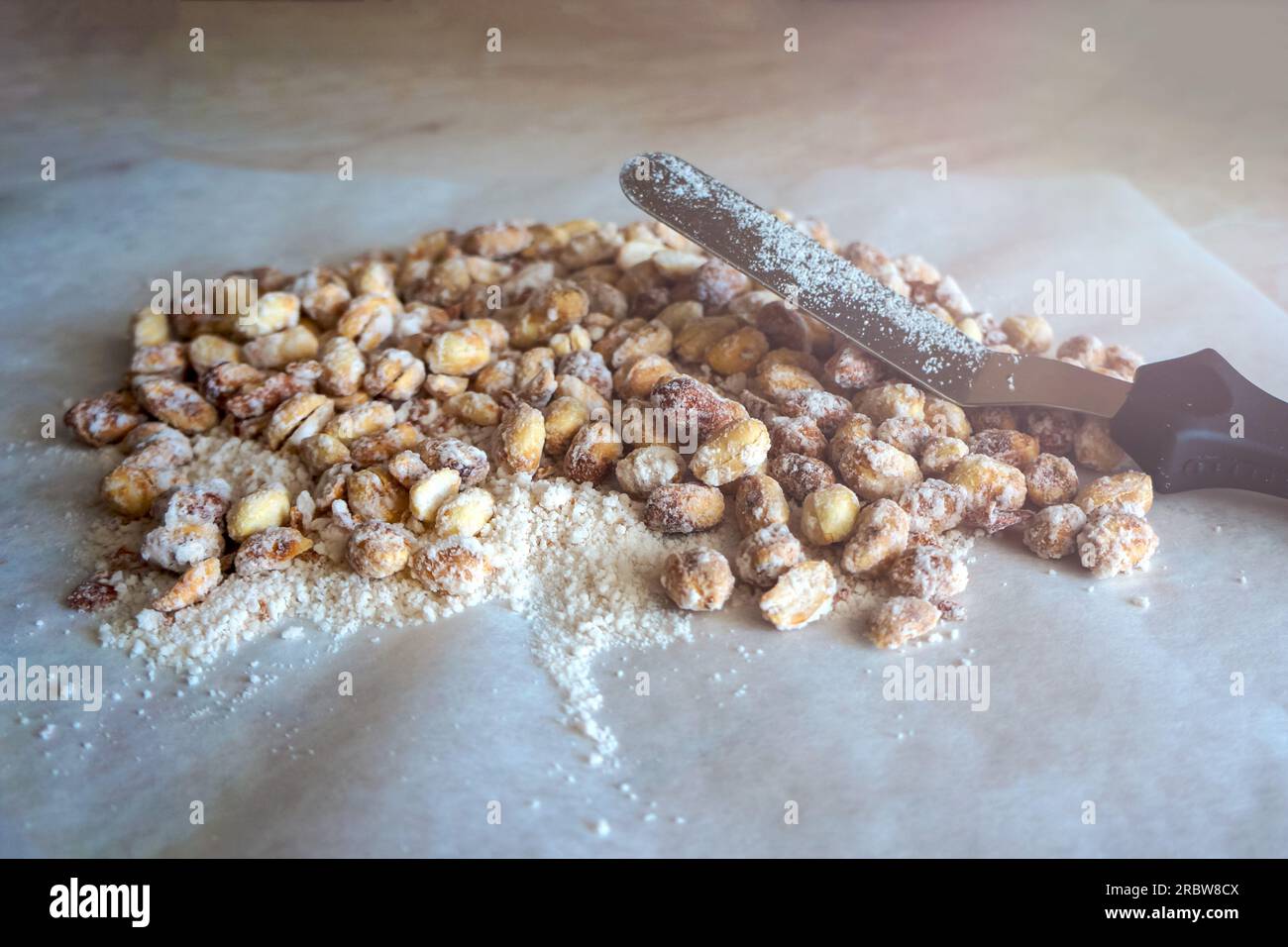 Roasted peanuts in icing sugar. Peanut in powdered sugar with a metal ...