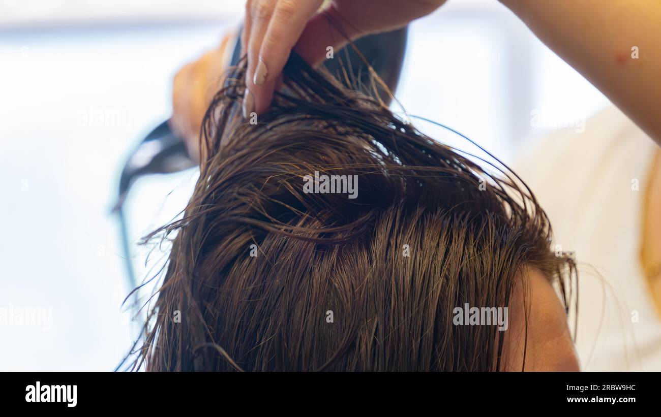 drying hair with a hair dryer at the barbershop Stock Photo - Alamy