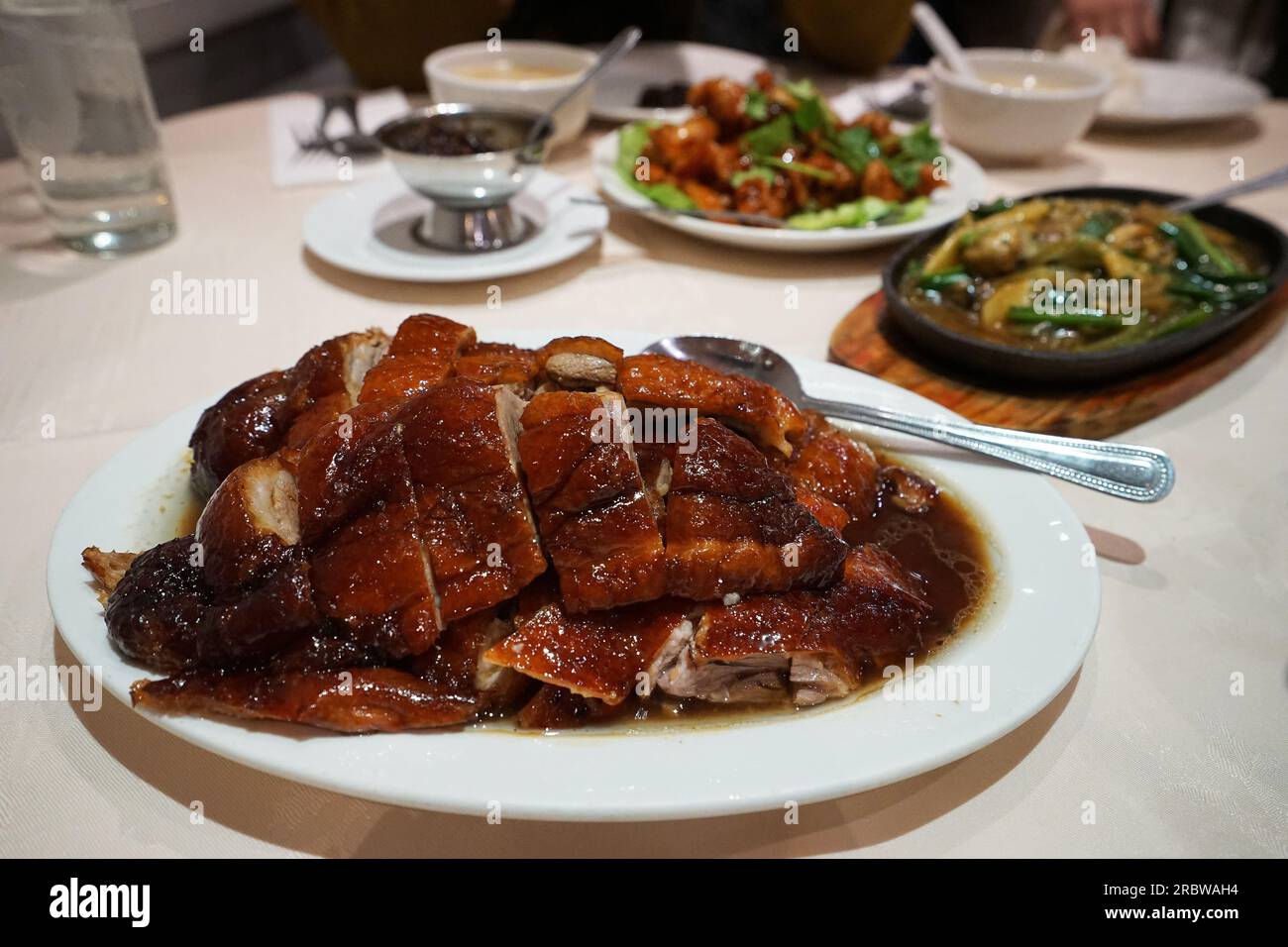 Close up Chinese roasted honey duck with stir fry vegetables and orange ...