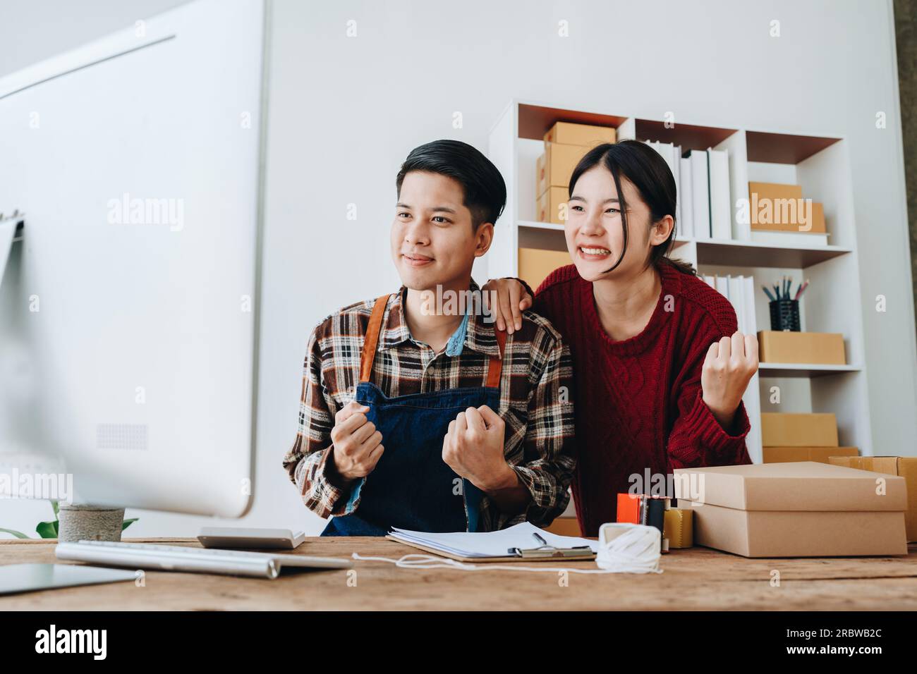 A young Asian couple shows delight and smiles on their faces when they ...