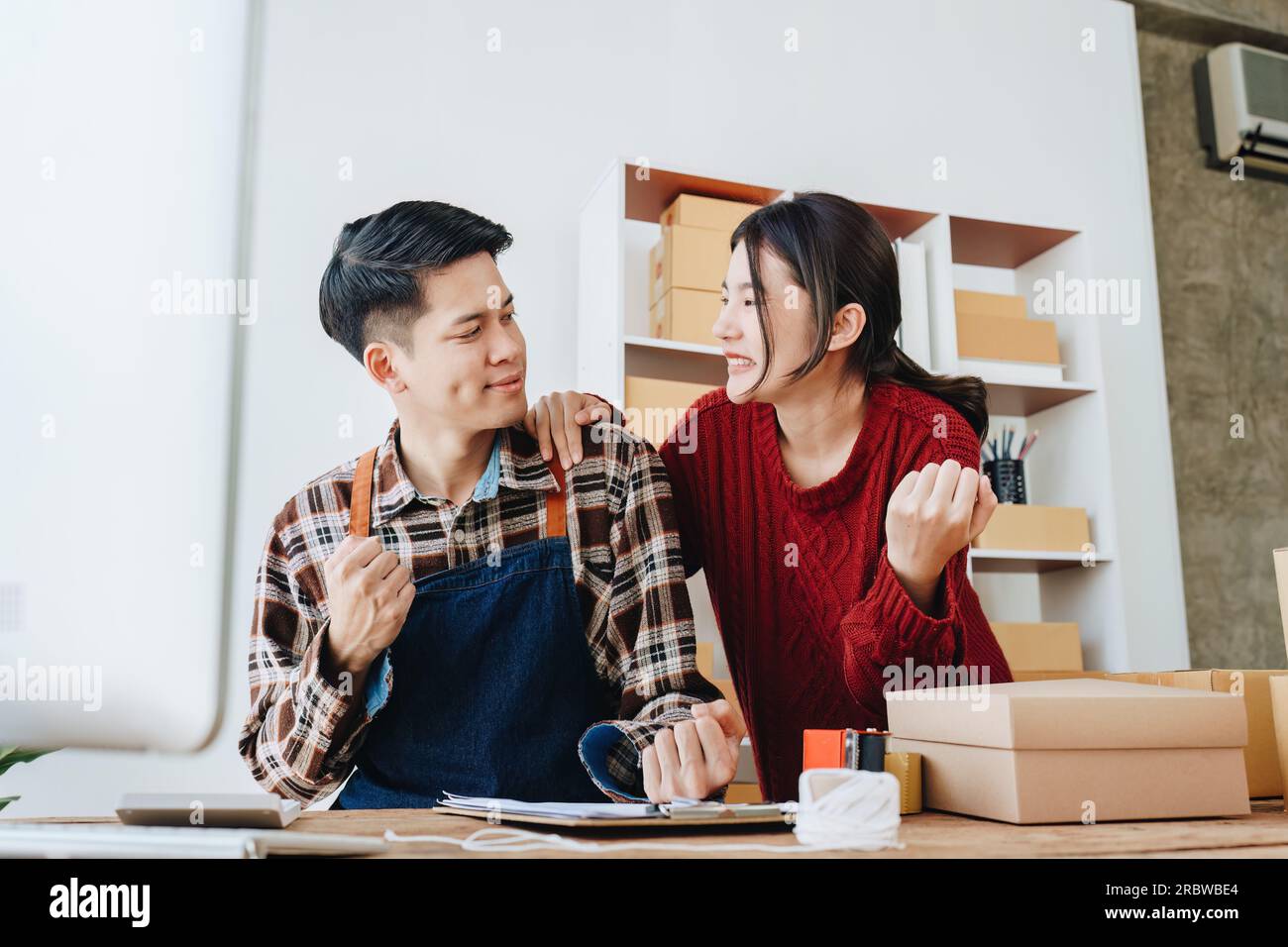 A young Asian couple shows delight and smiles on their faces when they ...