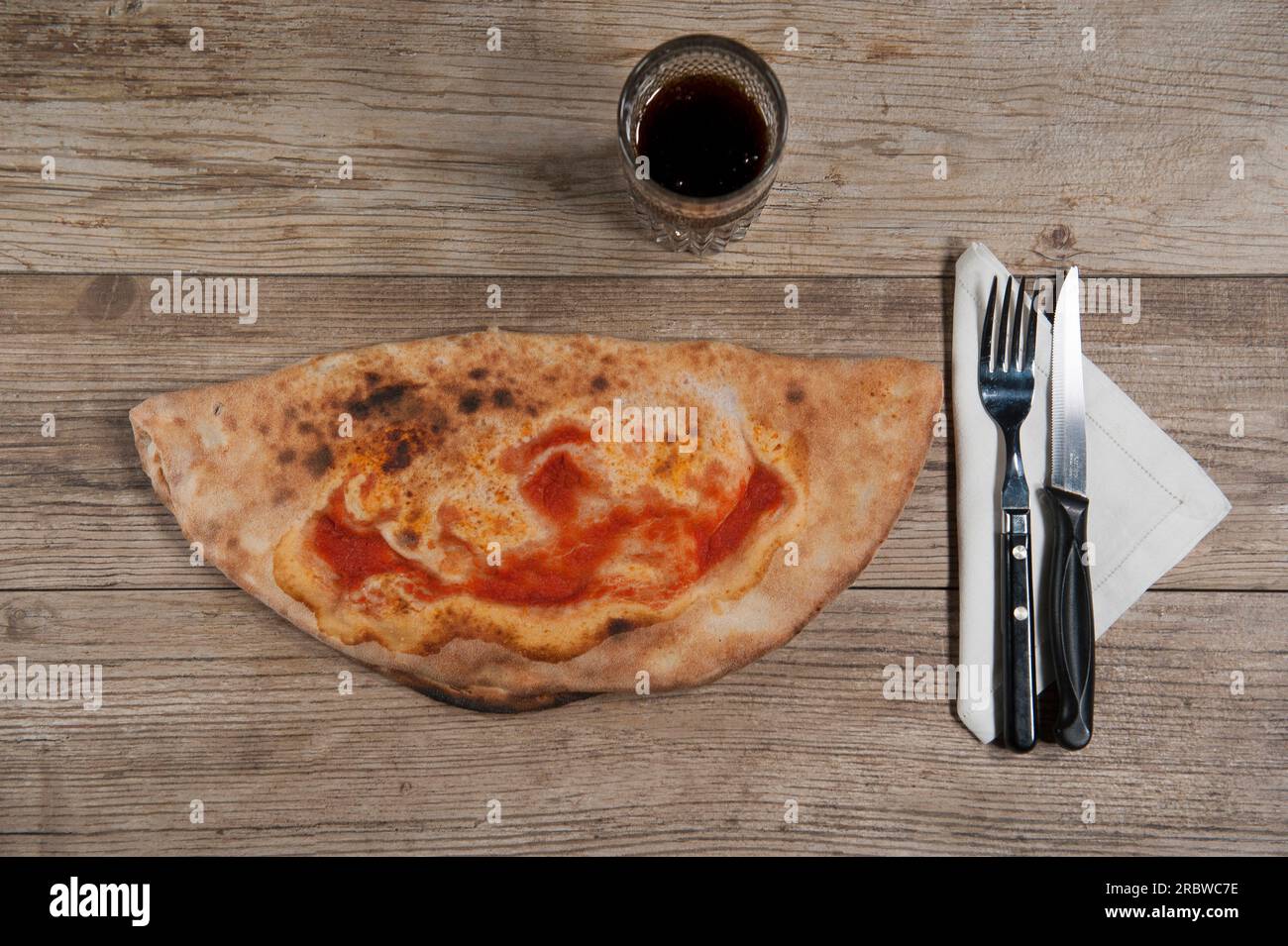 Calzone, Tipica pizza italiana. Typical Pizza stuffed with mozzarella cheese, ham and tomato ...