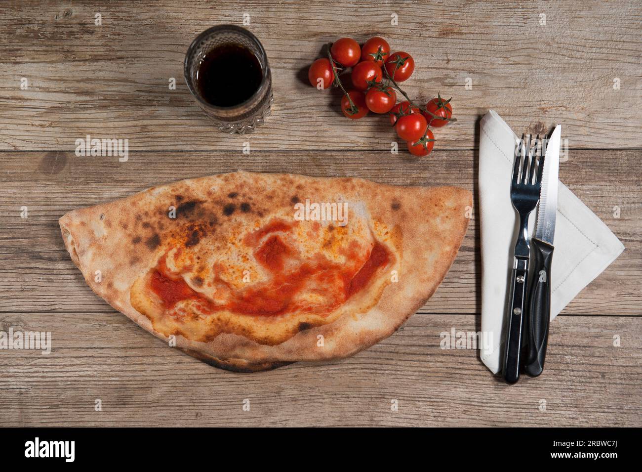 Calzone, Tipica pizza italiana. Typical Pizza stuffed with mozzarella cheese, ham and tomato ...