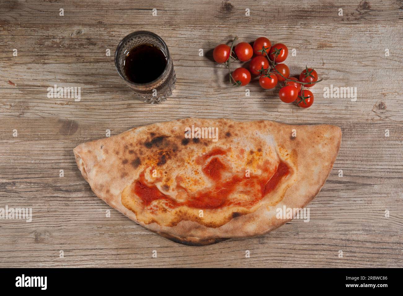 Calzone, Tipica pizza italiana. Typical Pizza stuffed with mozzarella cheese, ham and tomato ...