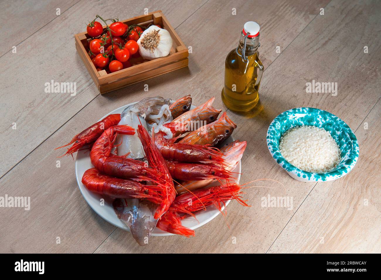 Rice, red prawns, squid, fish fillets, olive oil, garlic and tomato. Ingredients. Before cooking ...