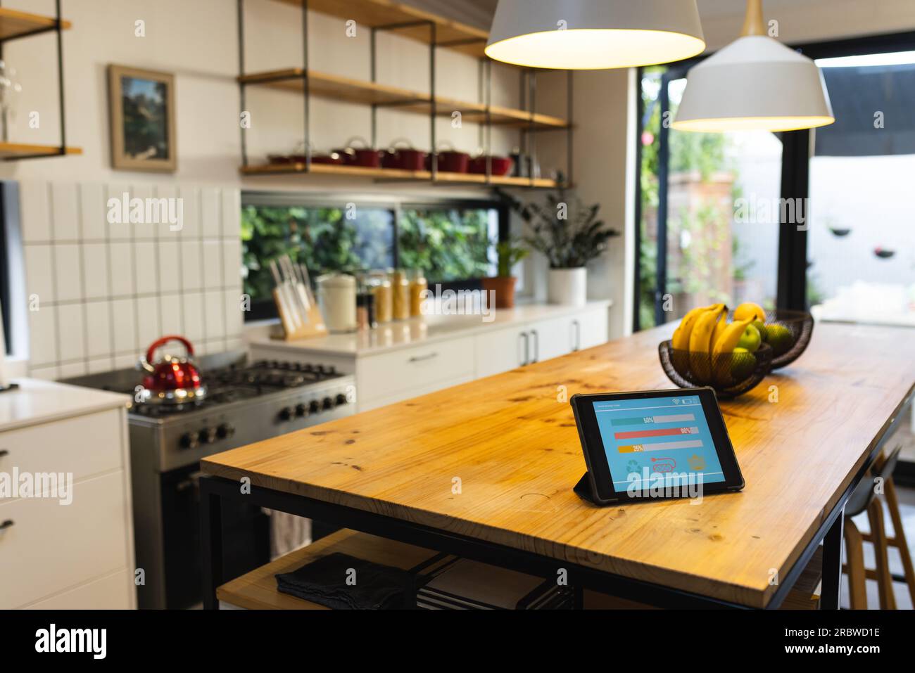 Tablet with smart home interface on wooden island countertop in kitchen ...