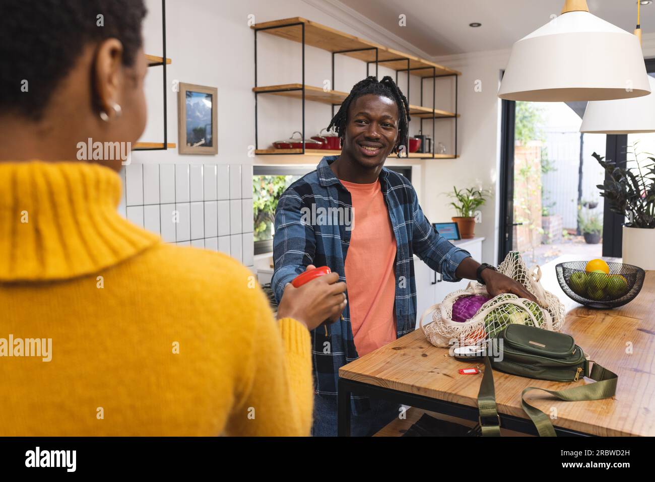 Happy african american couple unpacking groceries in kitchen Stock ...