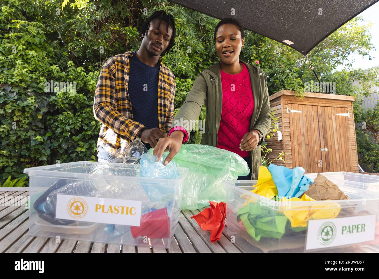 Happy african american couple collecting recycling in garden Stock ...