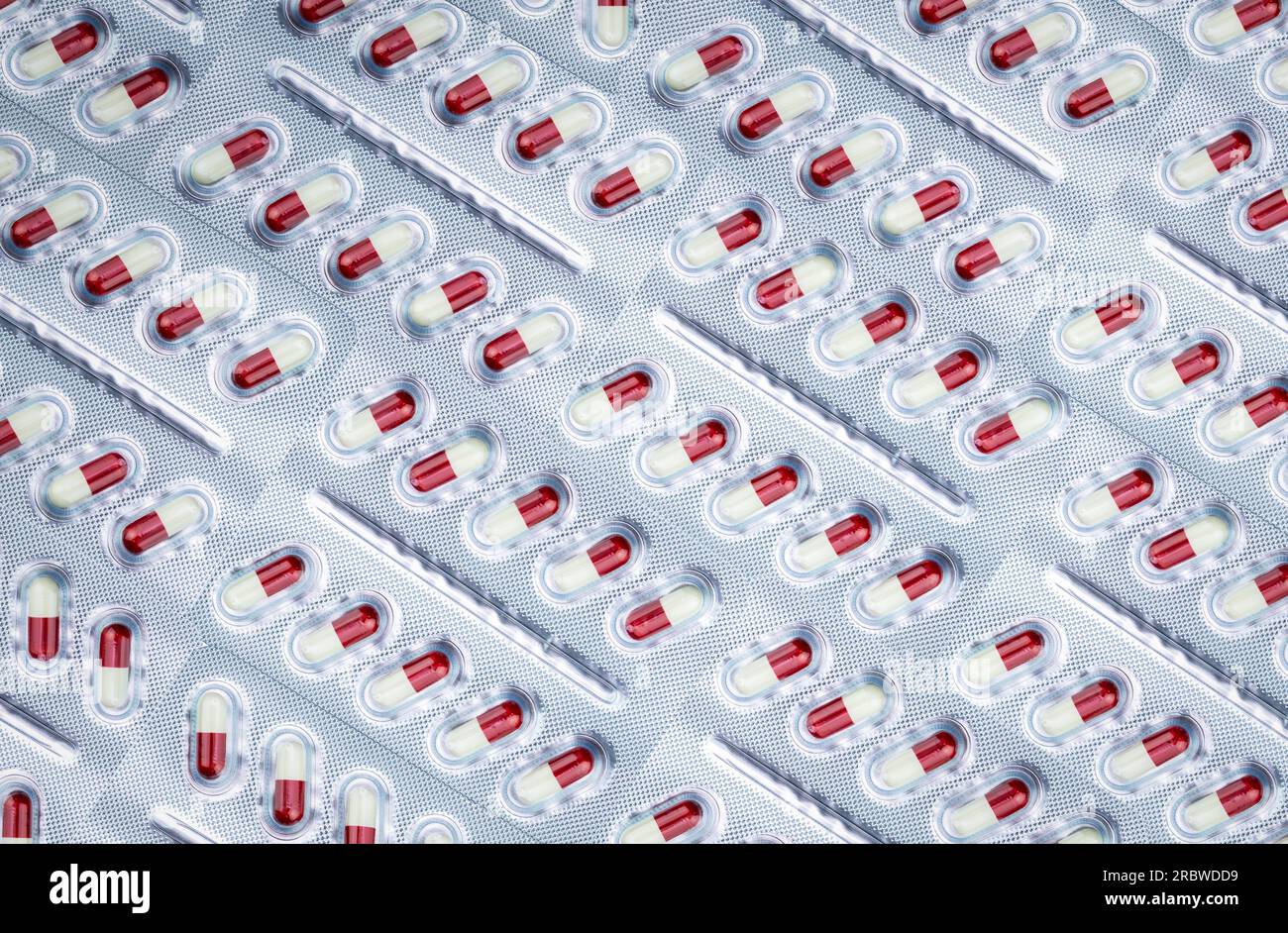Full frame of white-red capsule pill in aluminum foil blister pack ...