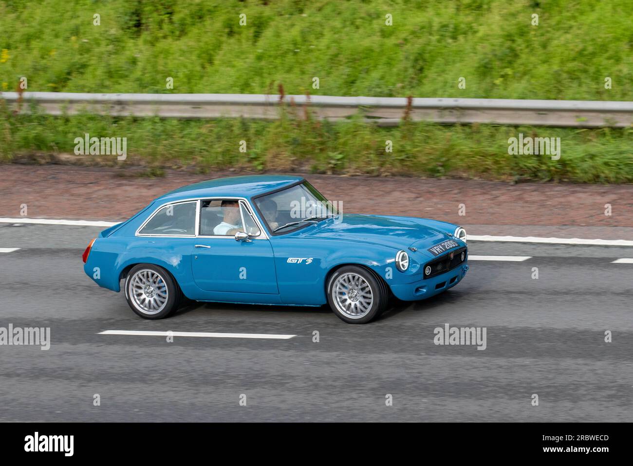 1978 70s seventies modified Blue MG B GT; travelling at speed on the M6 ...