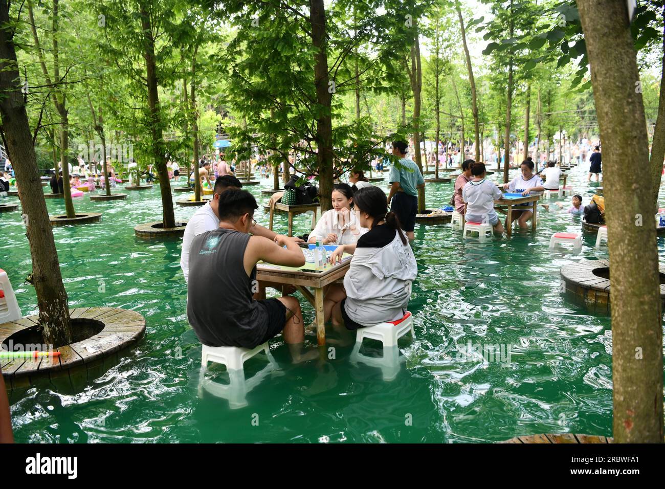People play mahjong while cooling their feet in water to escape the ...