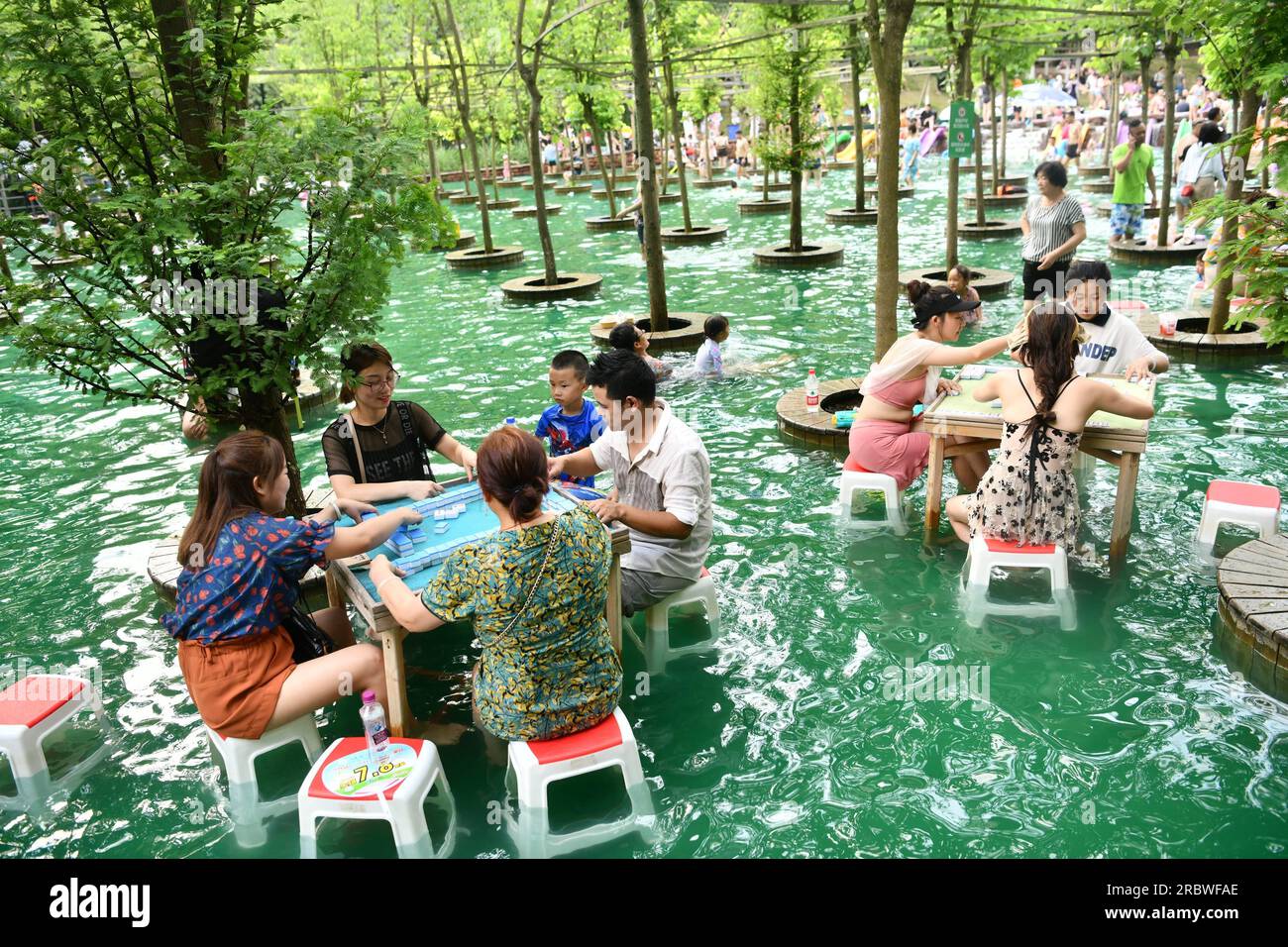 People play mahjong while cooling their feet in water to escape the ...