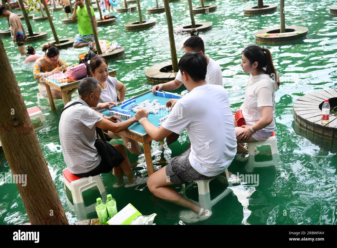 People play mahjong while cooling their feet in water to escape the ...