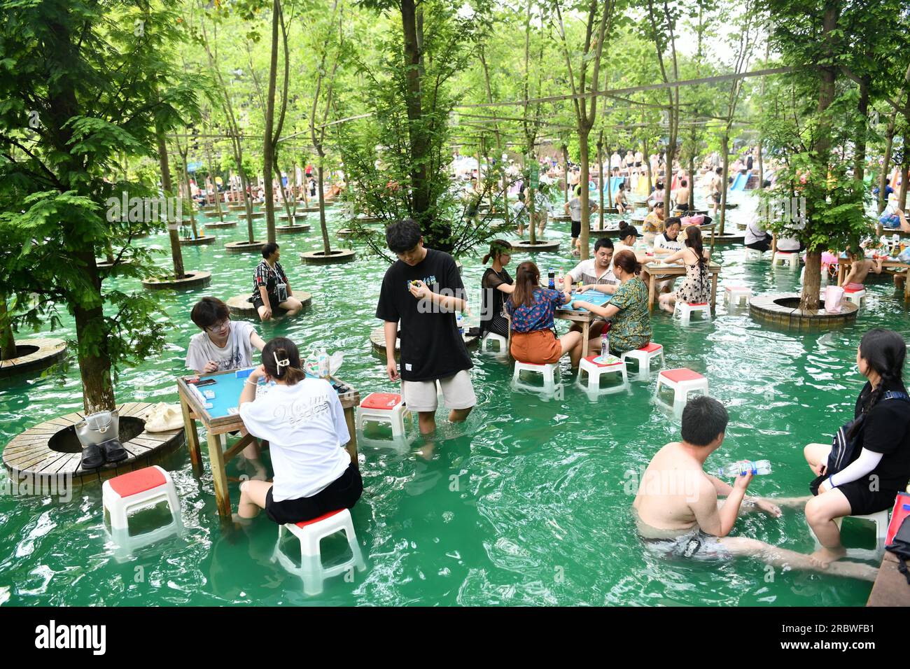 People play mahjong while cooling their feet in water to escape the ...