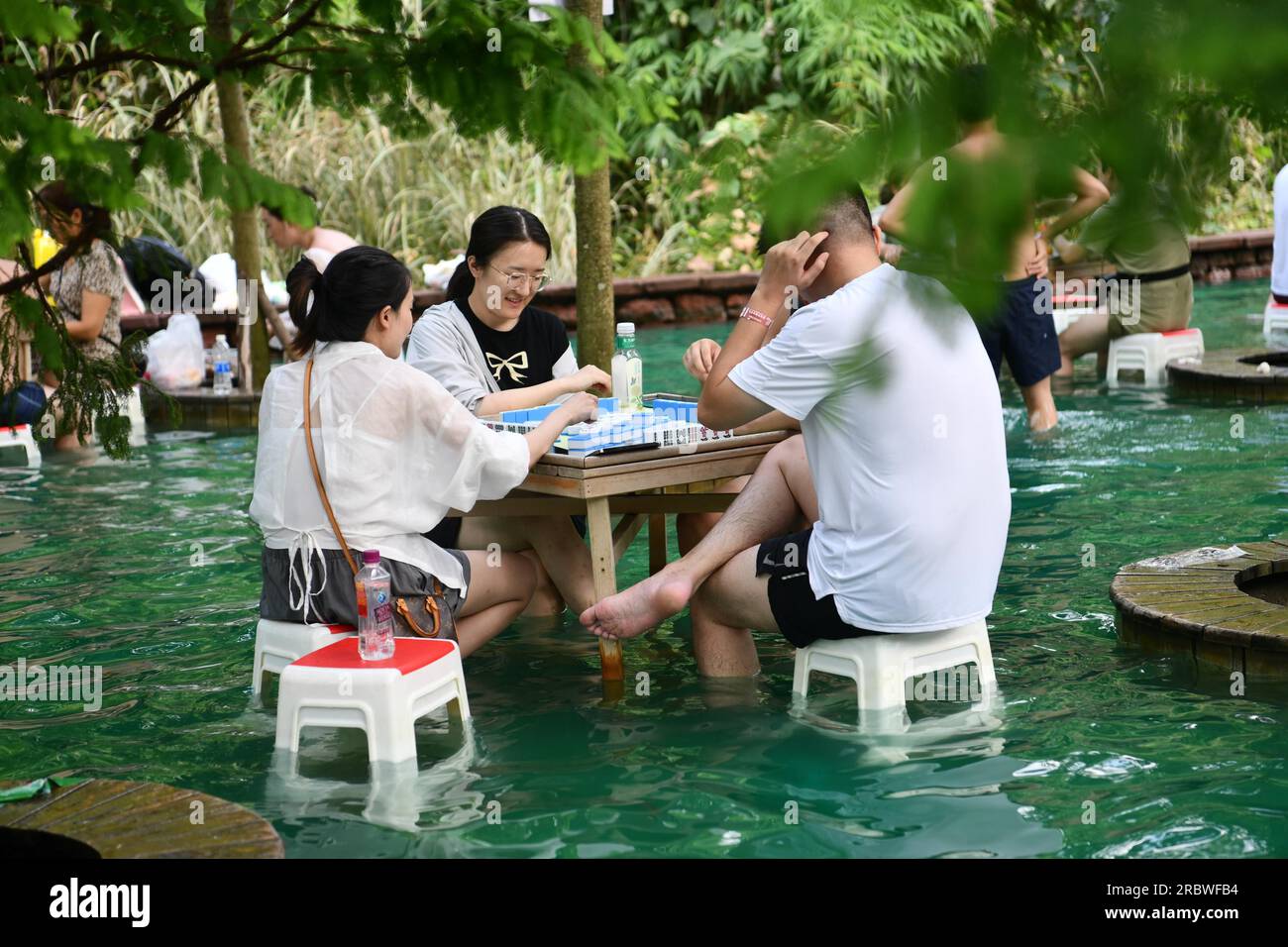People play mahjong while cooling their feet in water to escape the ...