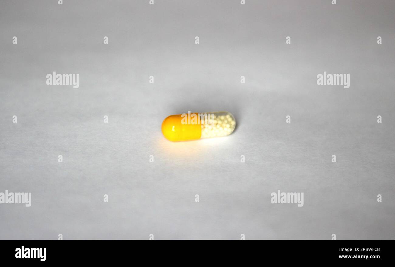 Pill on a white paper background Stock Photo - Alamy