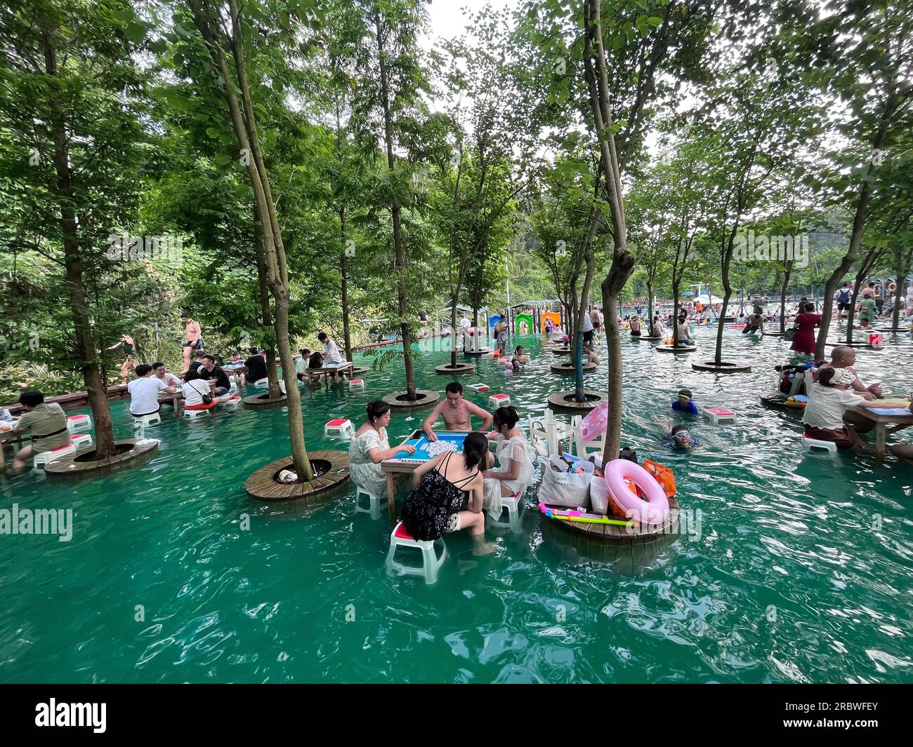 People play mahjong while cooling their feet in water to escape the ...