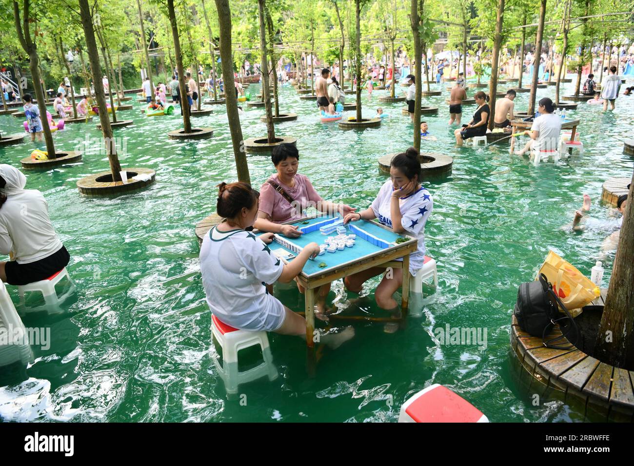 People play mahjong while cooling their feet in water to escape the ...