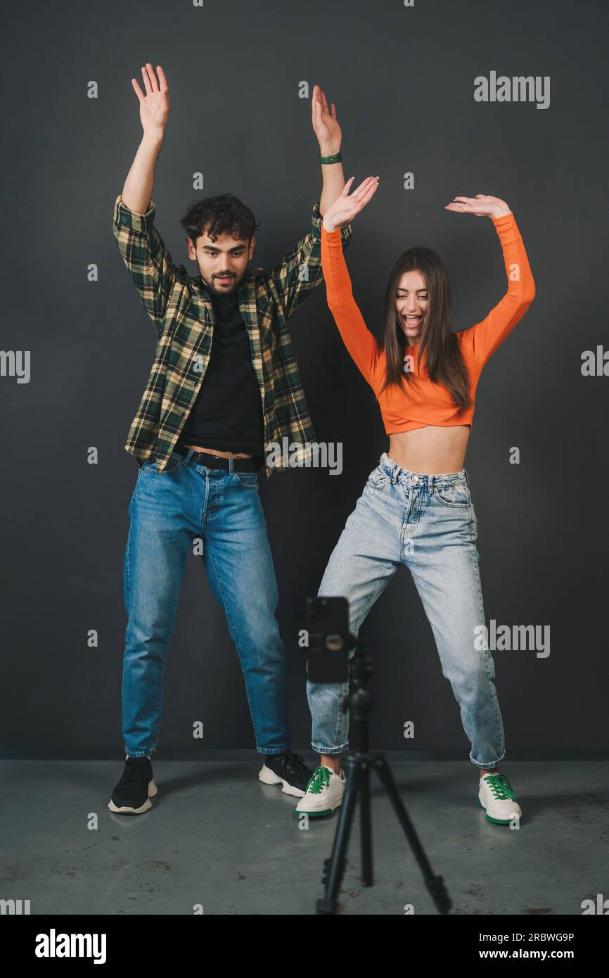Happy diverse friends with raised arms in studio Stock Photo - Alamy