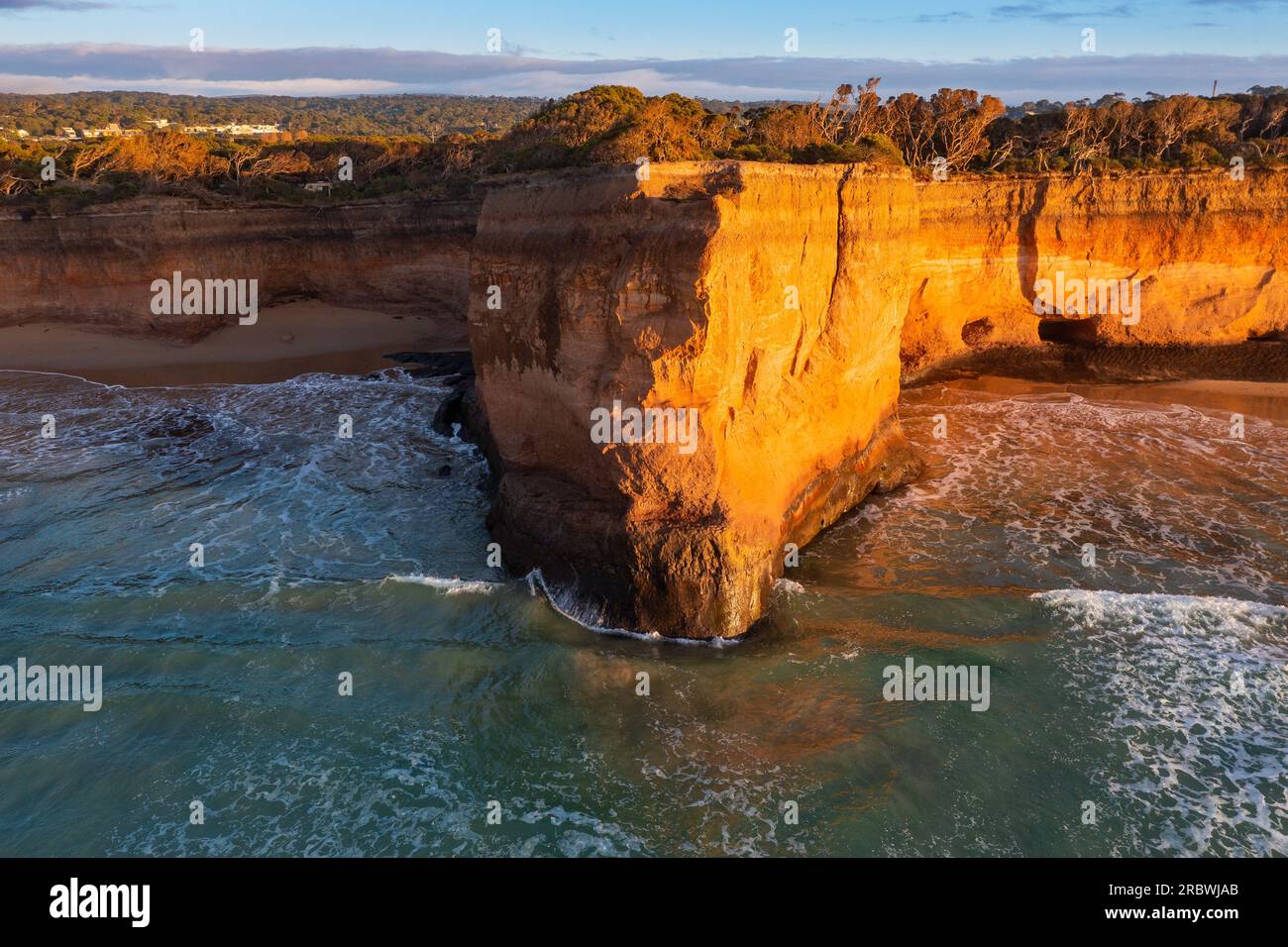Aerial view of waves crashing at the base of high sea cliffs at ...