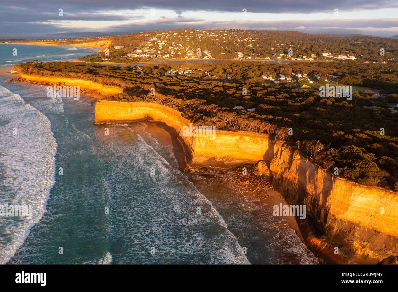 Aerial view of waves crashing at the base of high sea cliffs at ...