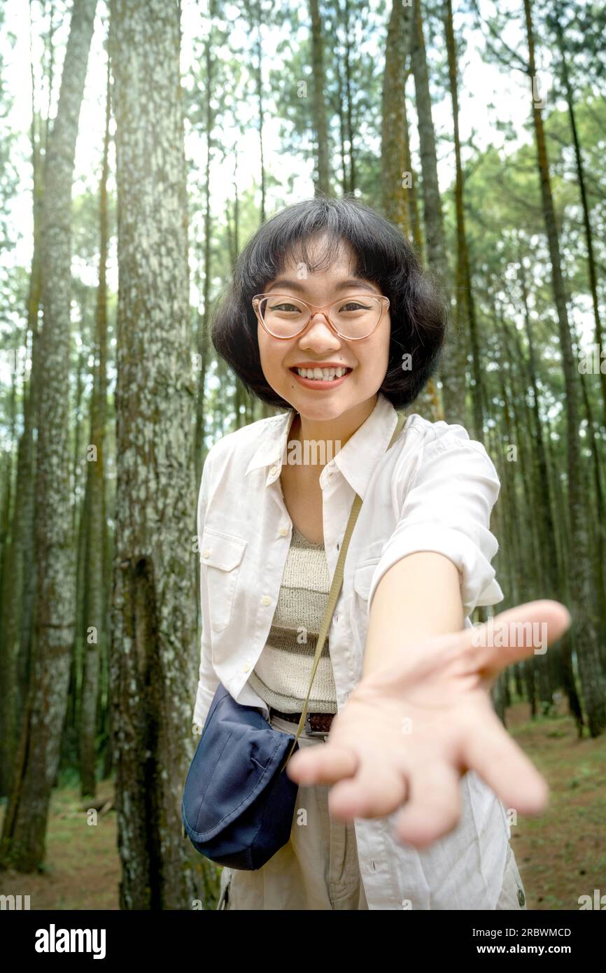 Asian woman walking around while giving her hand in the forest ...