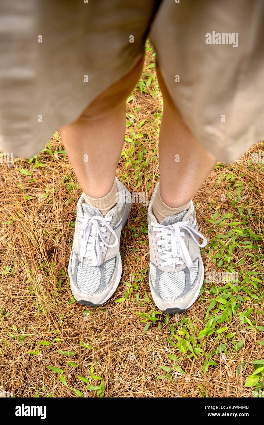 Women's legs with white shoes trekking in the forest. Traveling ...