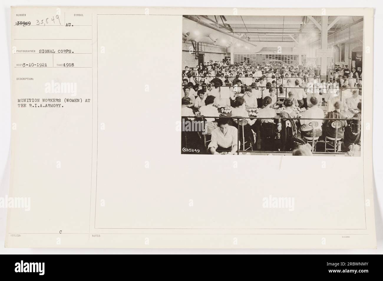 This photograph depicts women munition workers receiving issued ...