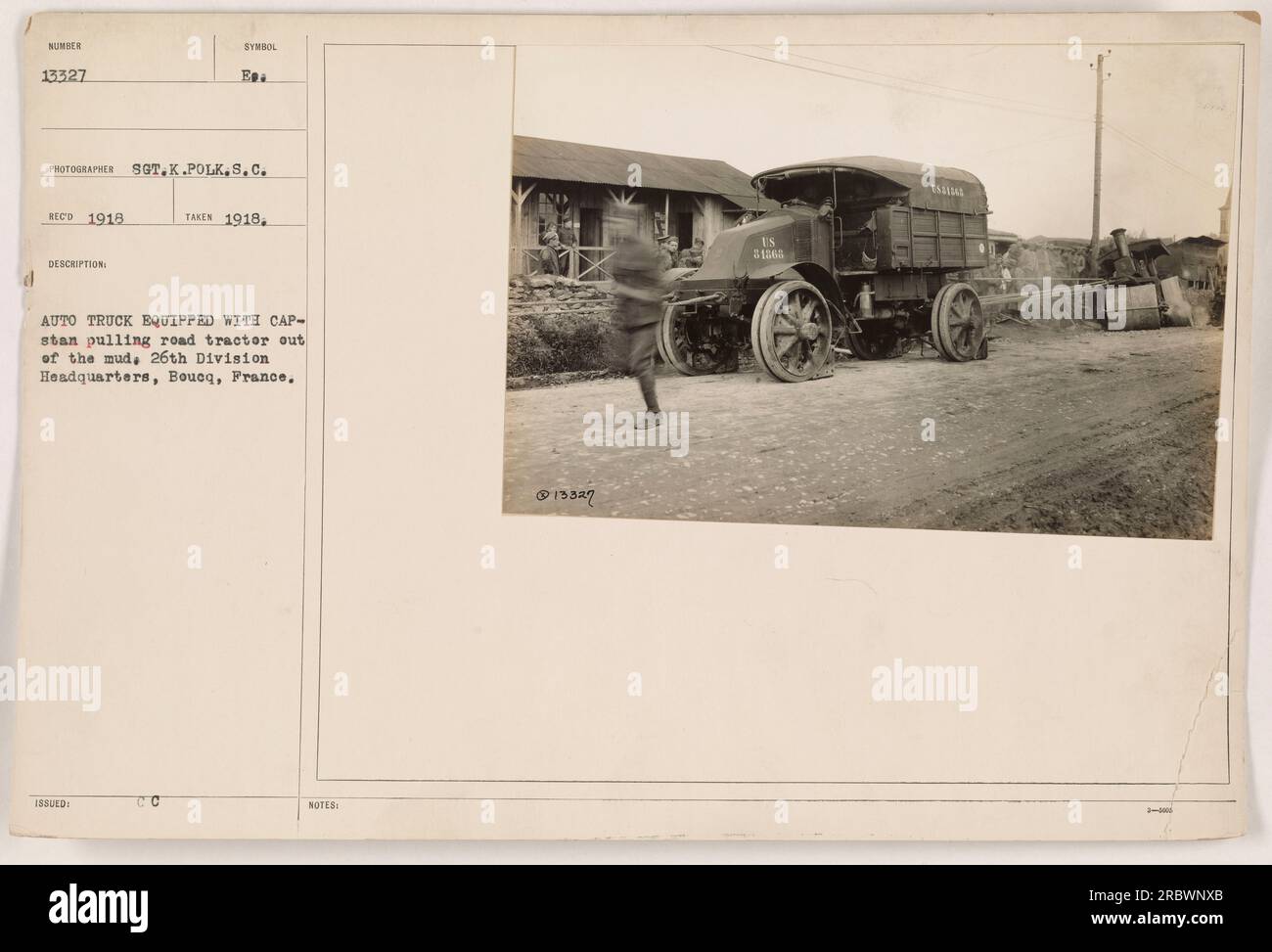 Auto truck equipped with a capstan pulling road tractor out of the mud ...