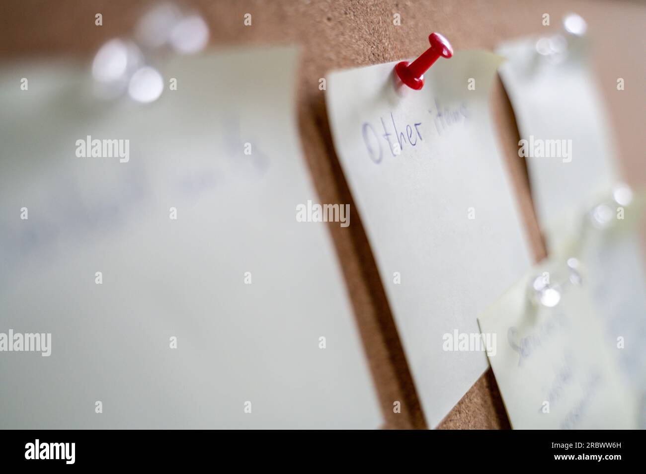 A lot of memos on cork bulletin board with pins. Tasks planning ...