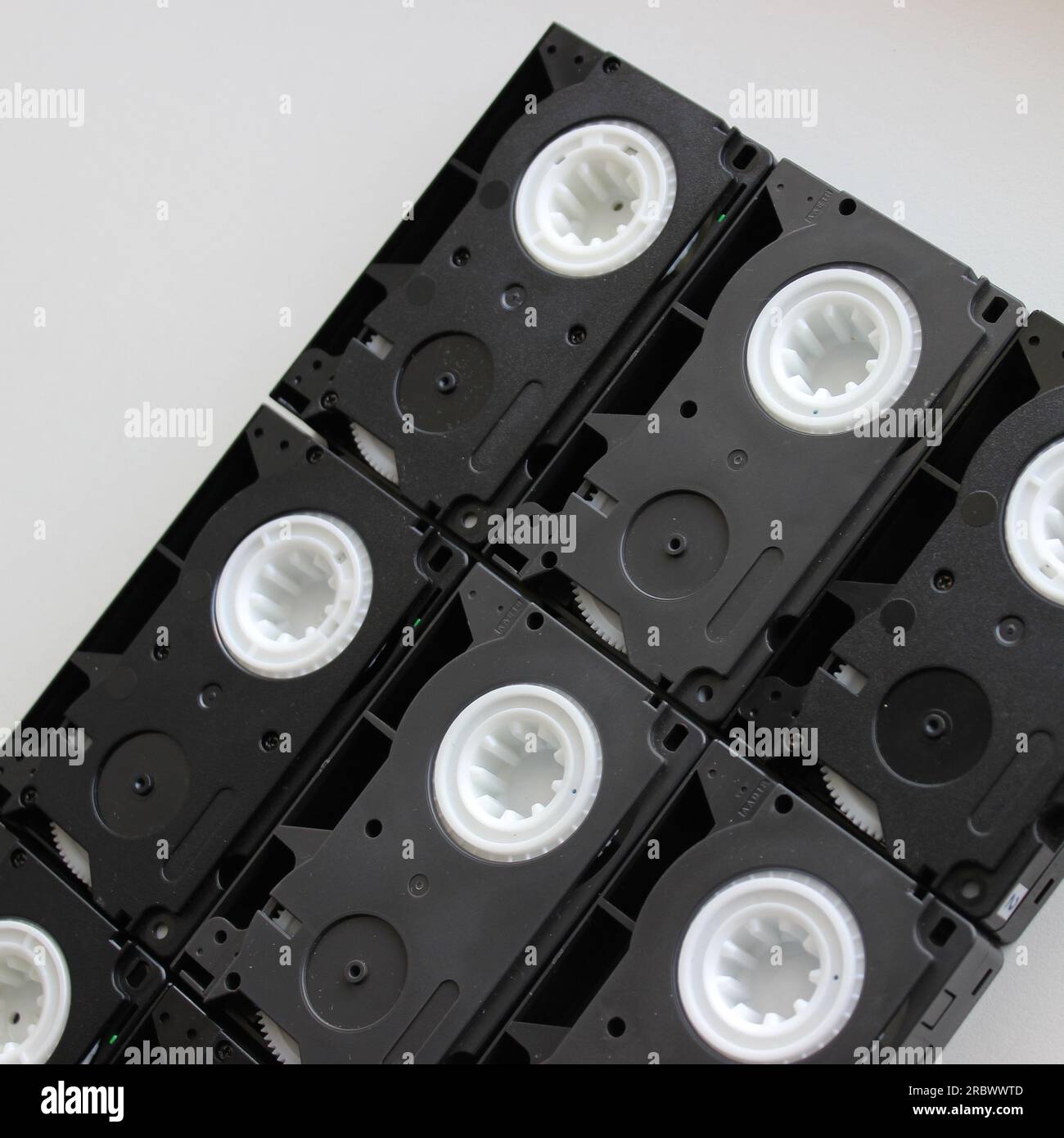 Black block made by rows of old small tape video cassettes on white ...