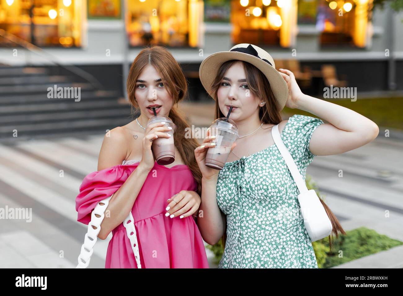 Two young beautiful smiling female in trendy summer clothes. Carefree women posing outdoors ...