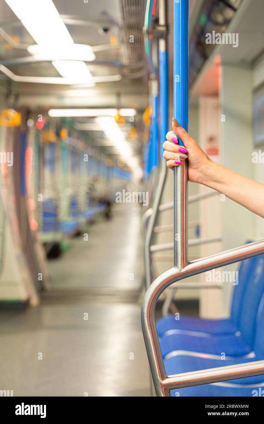 Woman holding hand on handrail in subway car. hand holding the railing ...