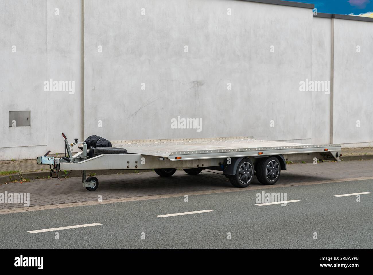 Side view of a platform car trailer standing on the side of the road ...