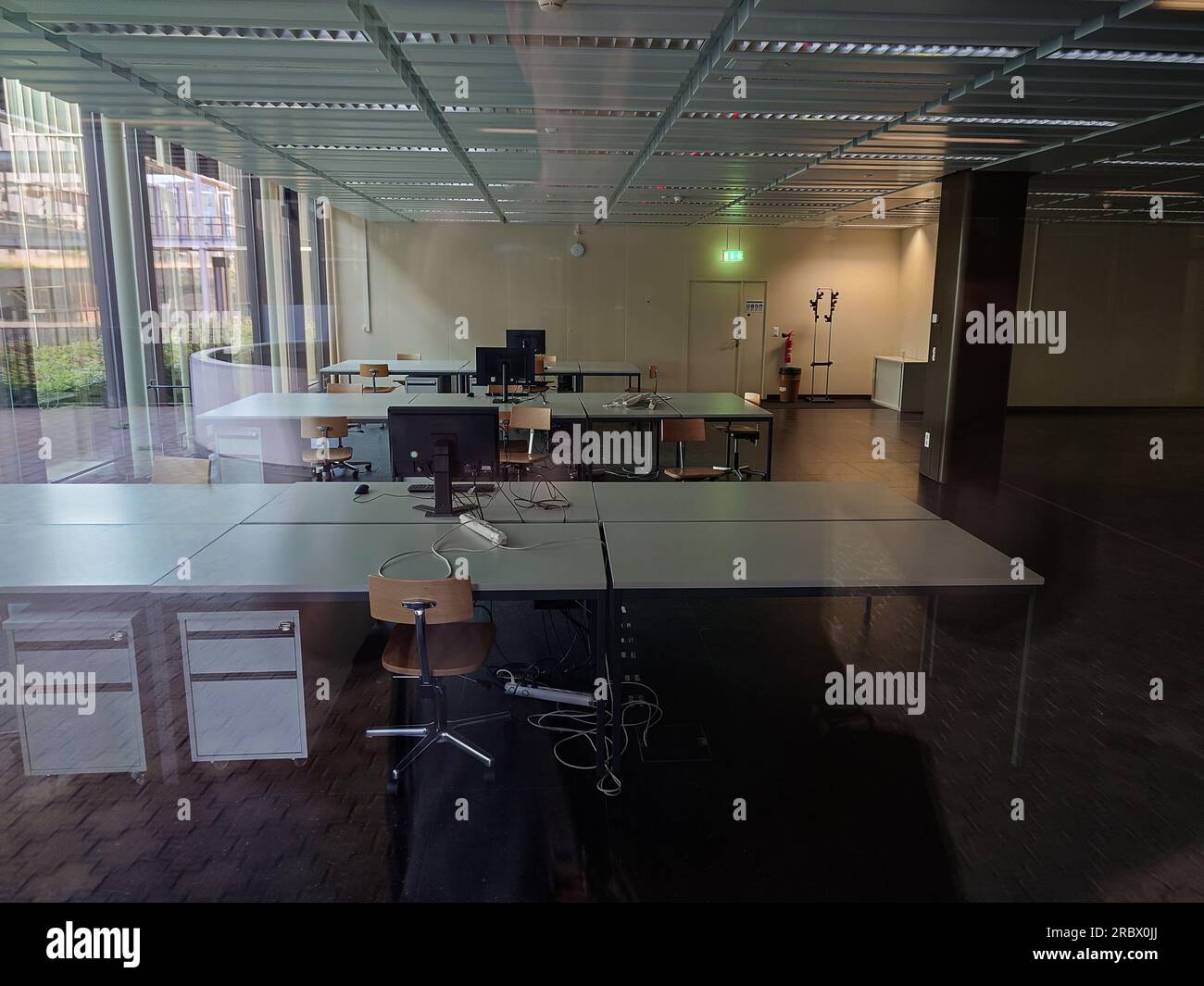 Empty office space with desks, chairs, computer monitors. Sunlight ...
