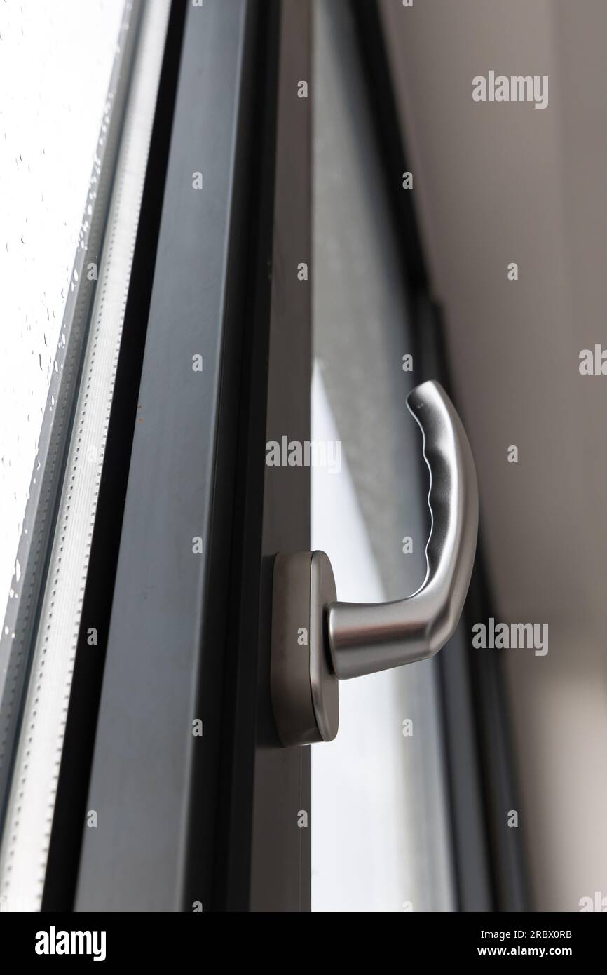 Tilt and turn window handle in a large window in a public building. The ...