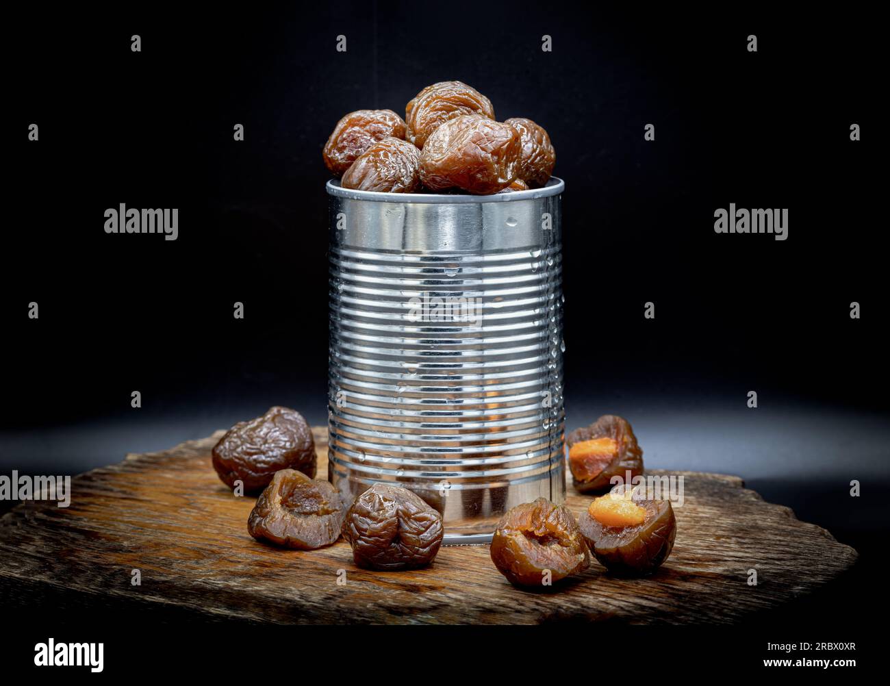 Flavored preserved chinese plums (Preserved fruits) in tin can on dark ...