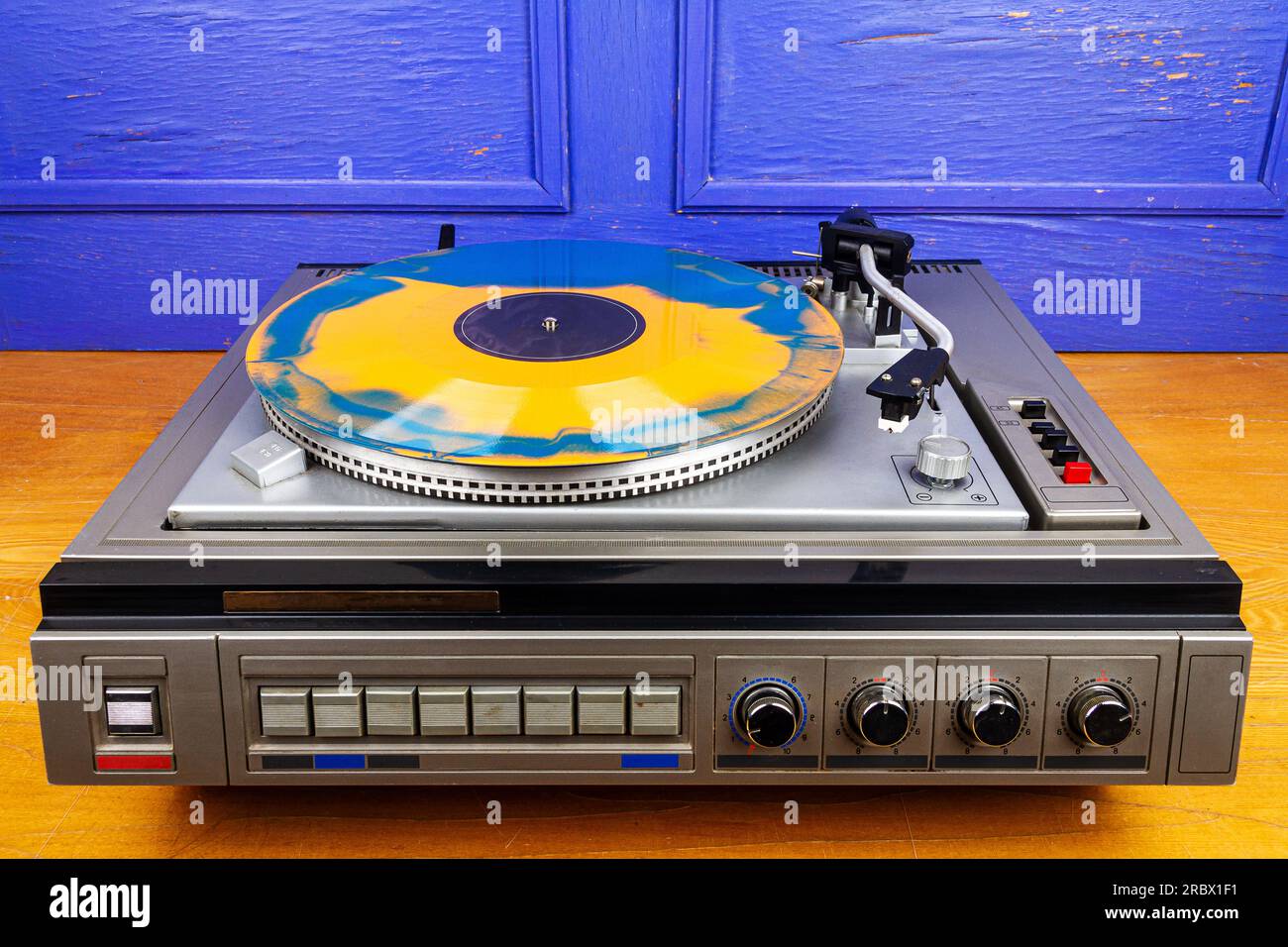 Vintage turntable vinyl record player with blue and orange vinyl on a ...